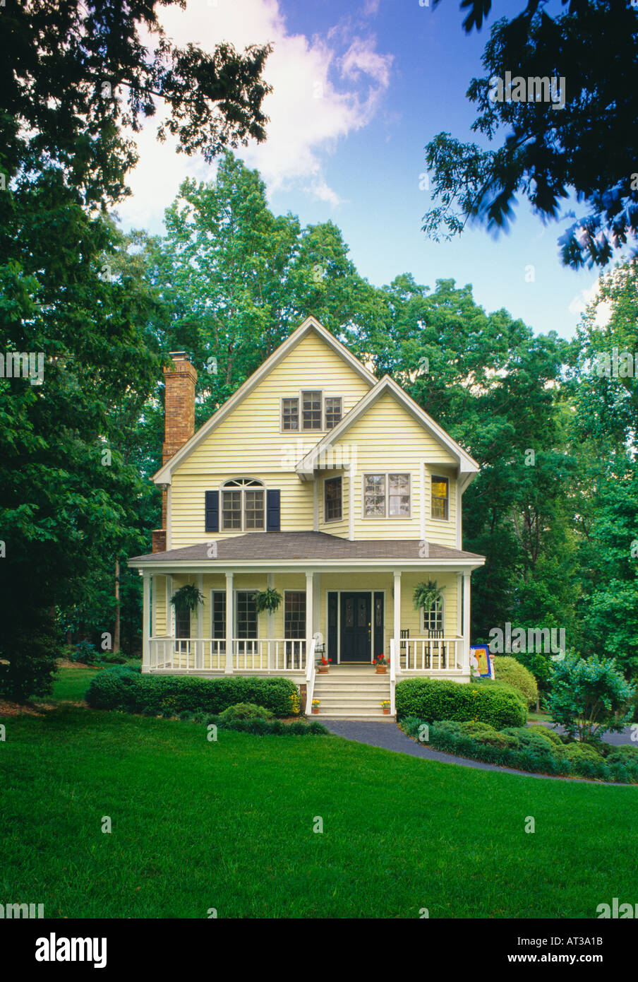 Charming two story yellow house with a large front porch on wooded lot ...