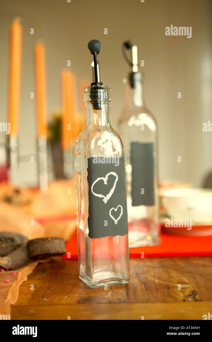 Two empty bottles on a table with a heart shaped design on one Stock ...