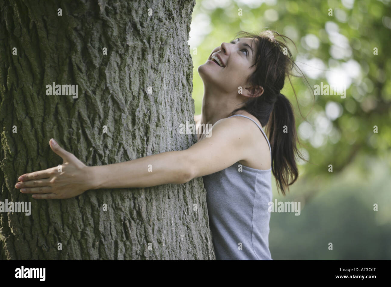 A young woman girl hugging a tree, close-up Stock Photo - Alamy