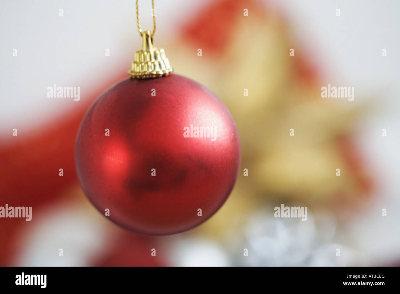 A single red bauble hanging on a gold thread Stock Photo - Alamy