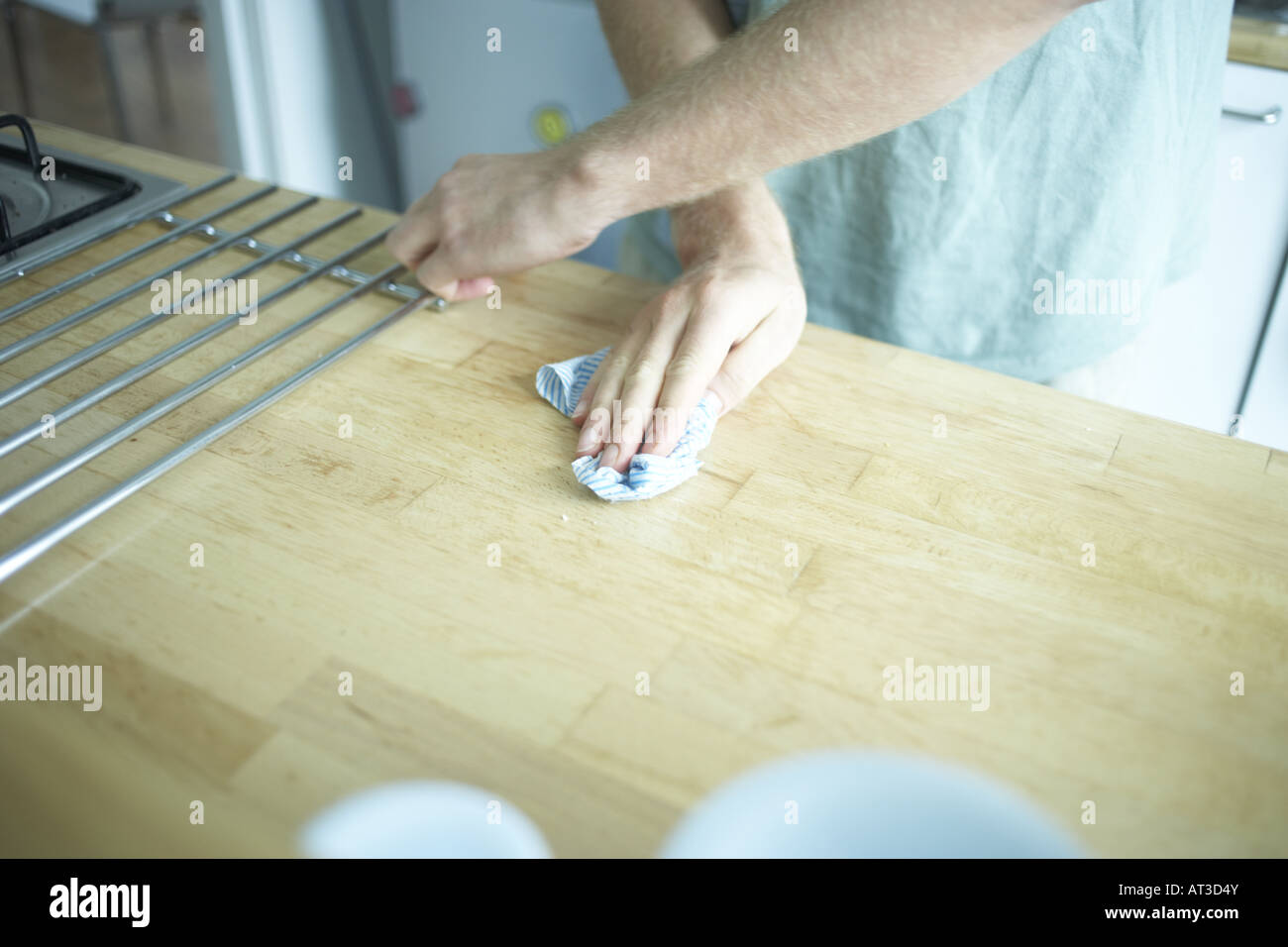 A woman wiping a kitchen work surface with a cloth Stock Photo - Alamy
