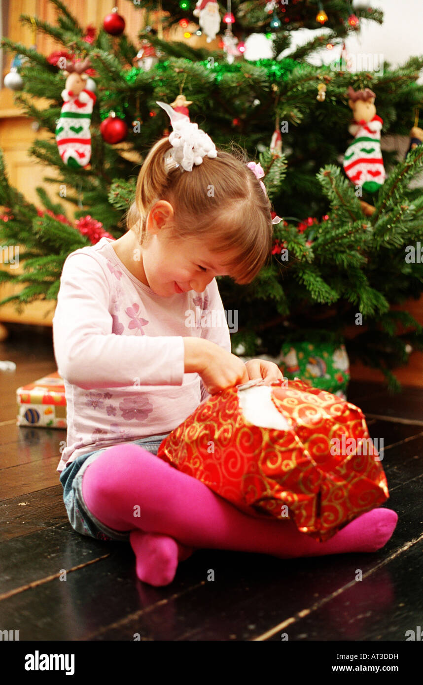 A girl opening a Christmas present Stock Photo - Alamy
