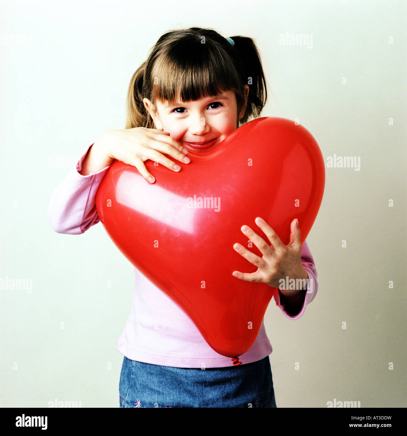 A small girl hugging a heart shaped balloon Stock Photo - Alamy