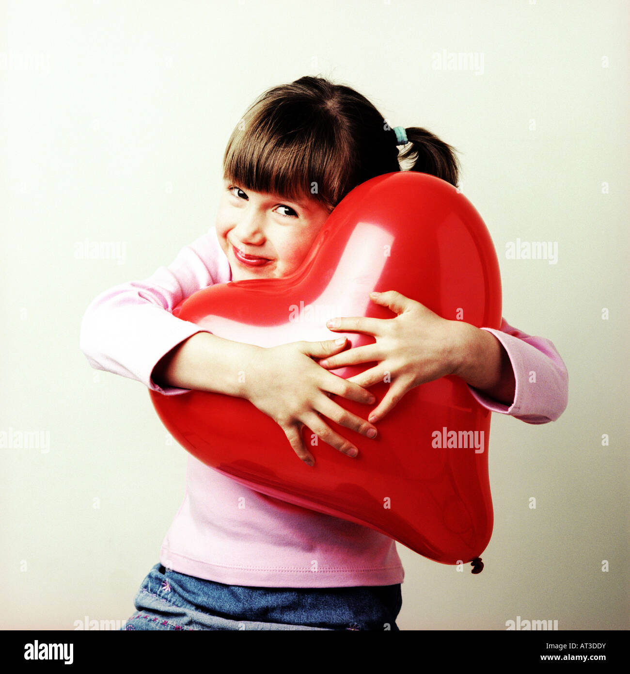 A small girl hugging a heart shaped balloon Stock Photo - Alamy