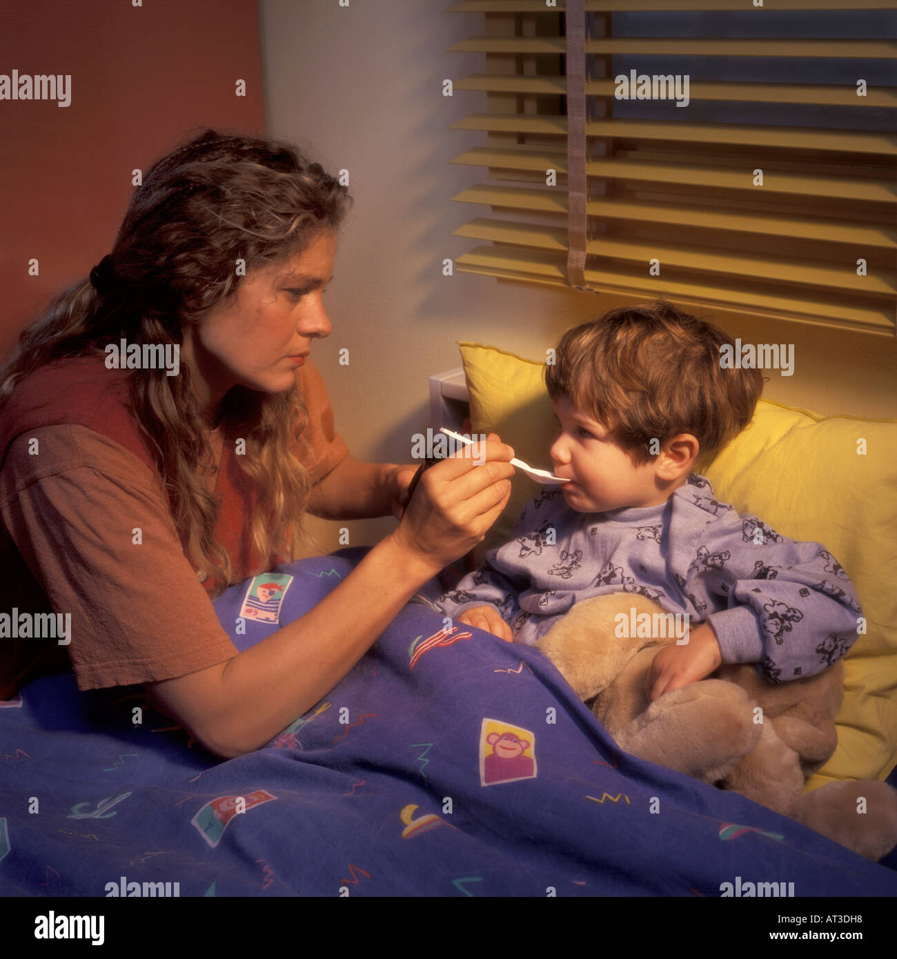 Mother gives a child a cough mixture Stock Photo - Alamy