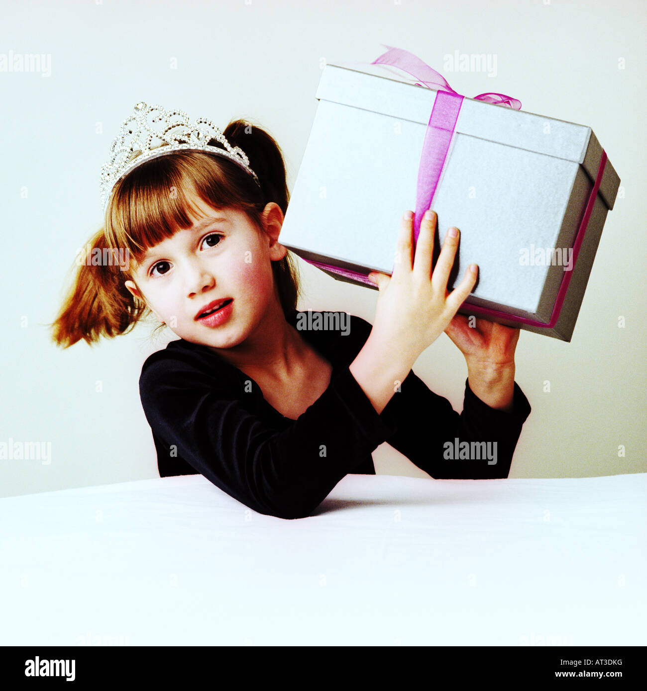 A girl shaking a present Stock Photo - Alamy