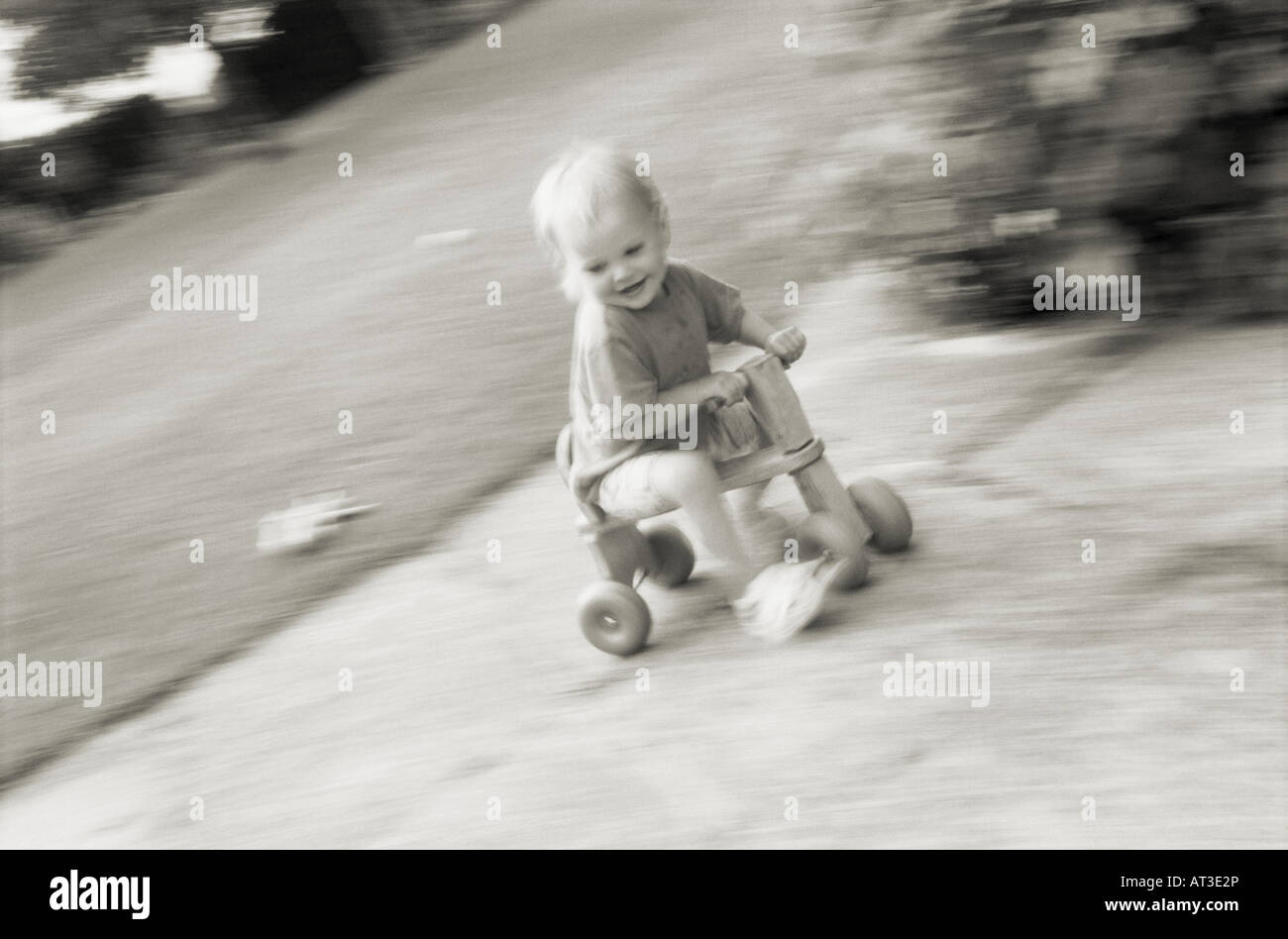 A small child riding a tricycle Stock Photo - Alamy