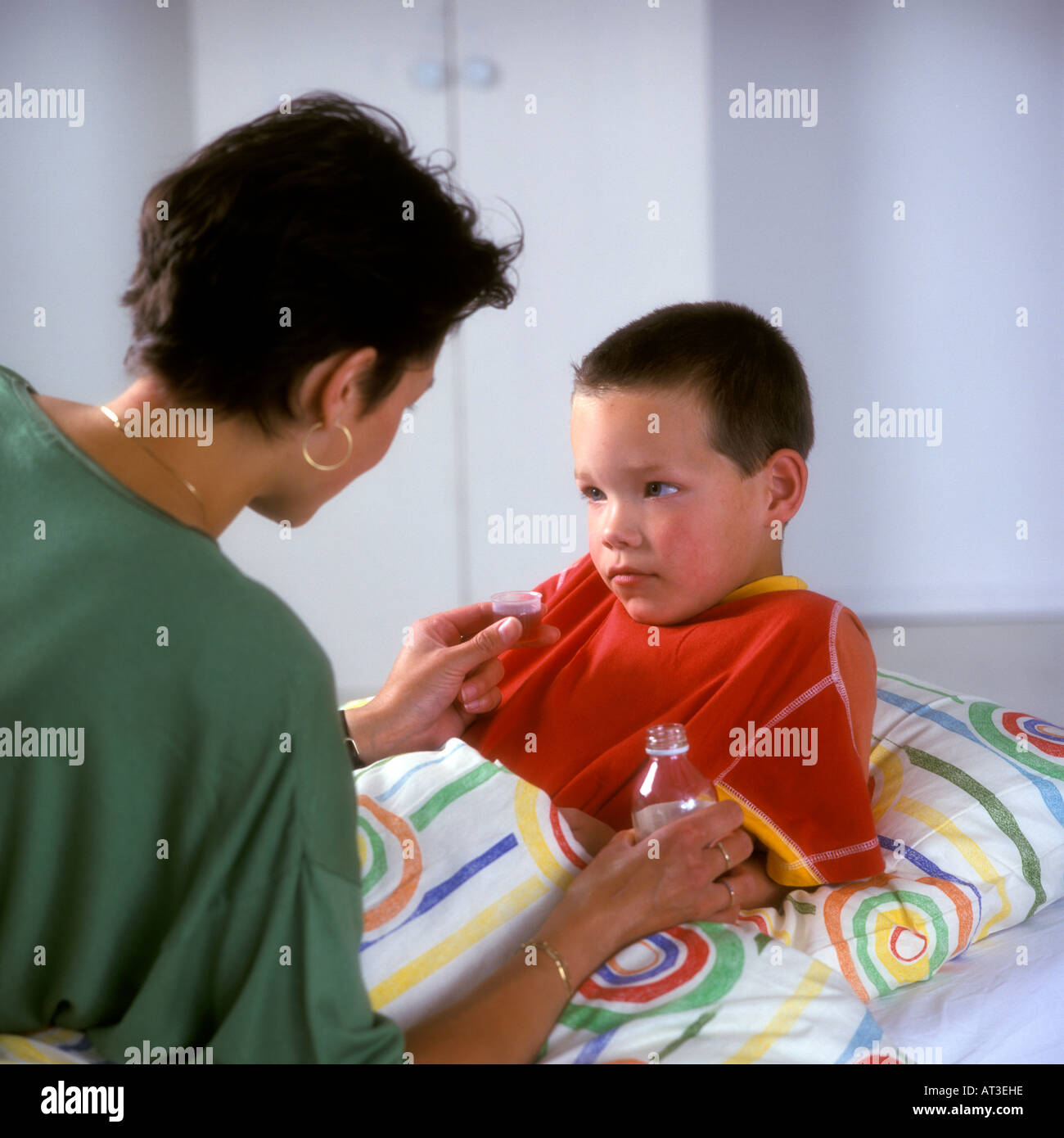 Mother gives a child a cough mixture Stock Photo - Alamy