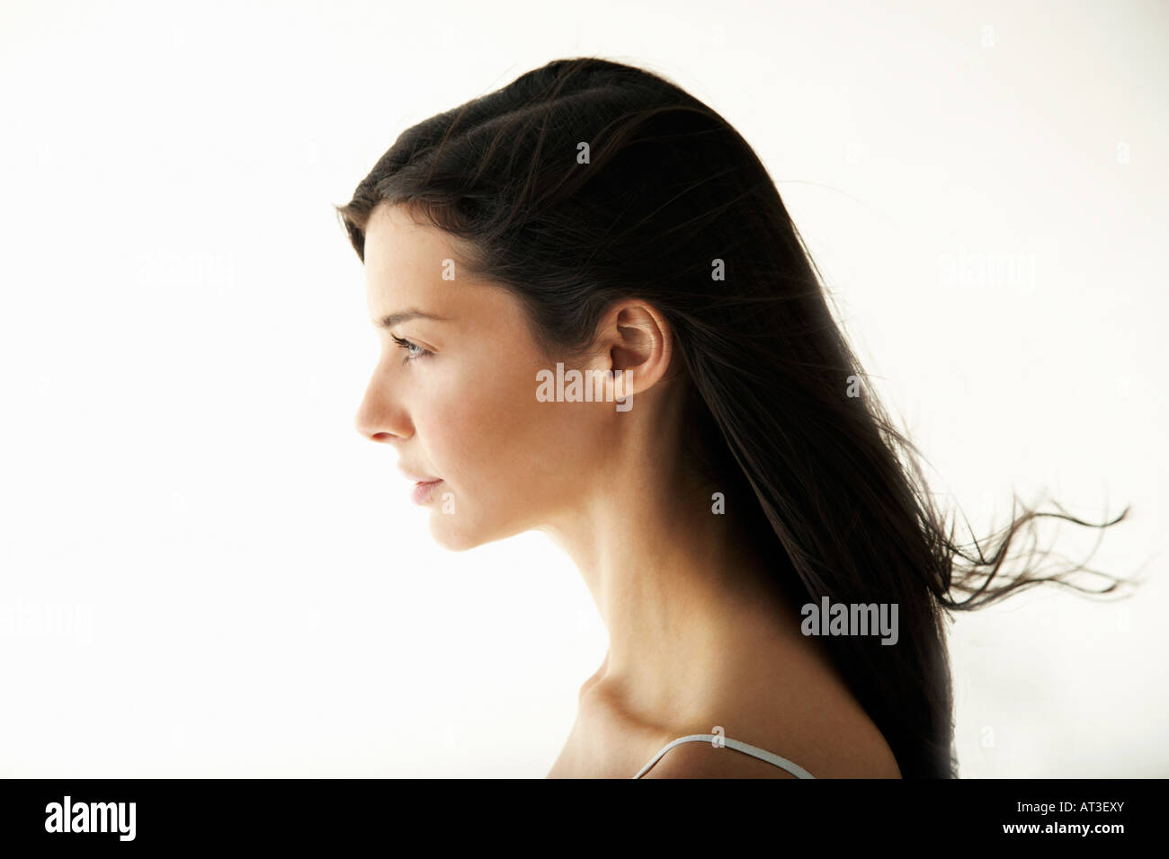 A young woman with wind blowing through her hair Stock Photo - Alamy