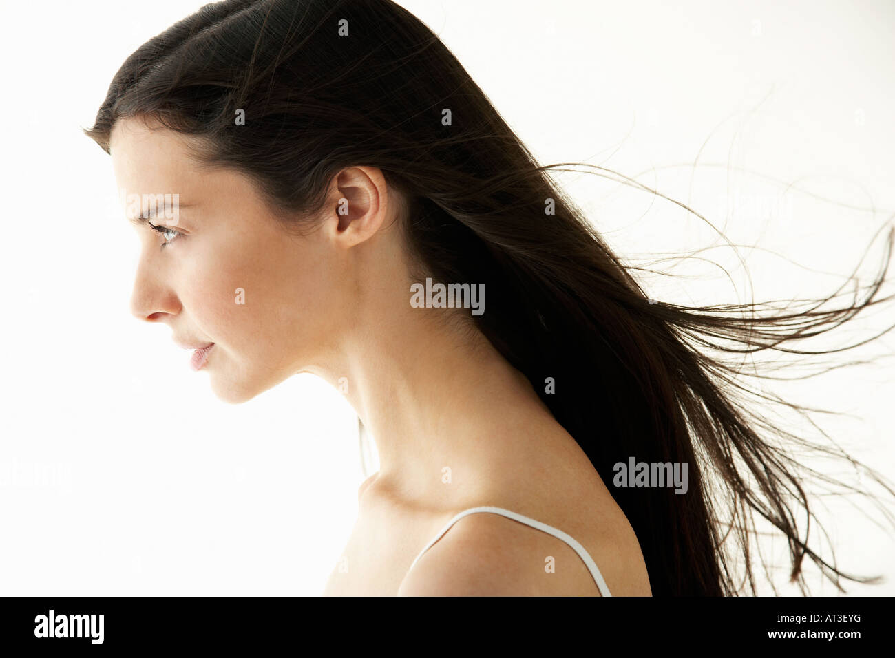 A young woman with wind blowing through her hair Stock Photo - Alamy