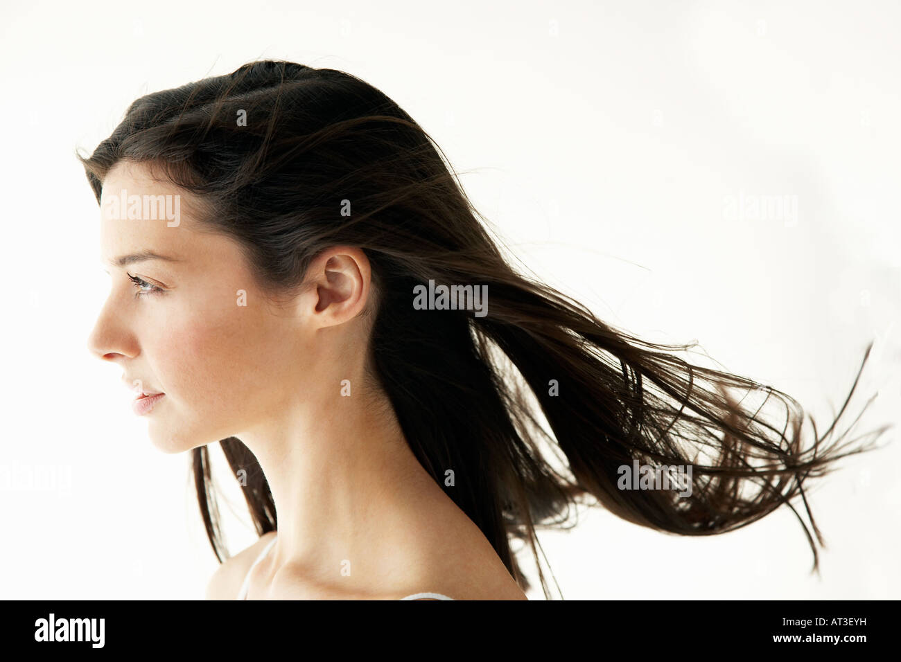 A young woman with wind blowing through her hair Stock Photo - Alamy