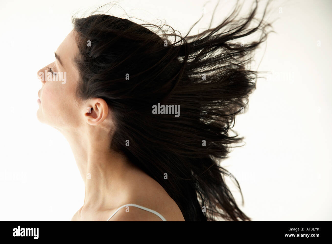 A young woman with wind blowing through her hair Stock Photo - Alamy