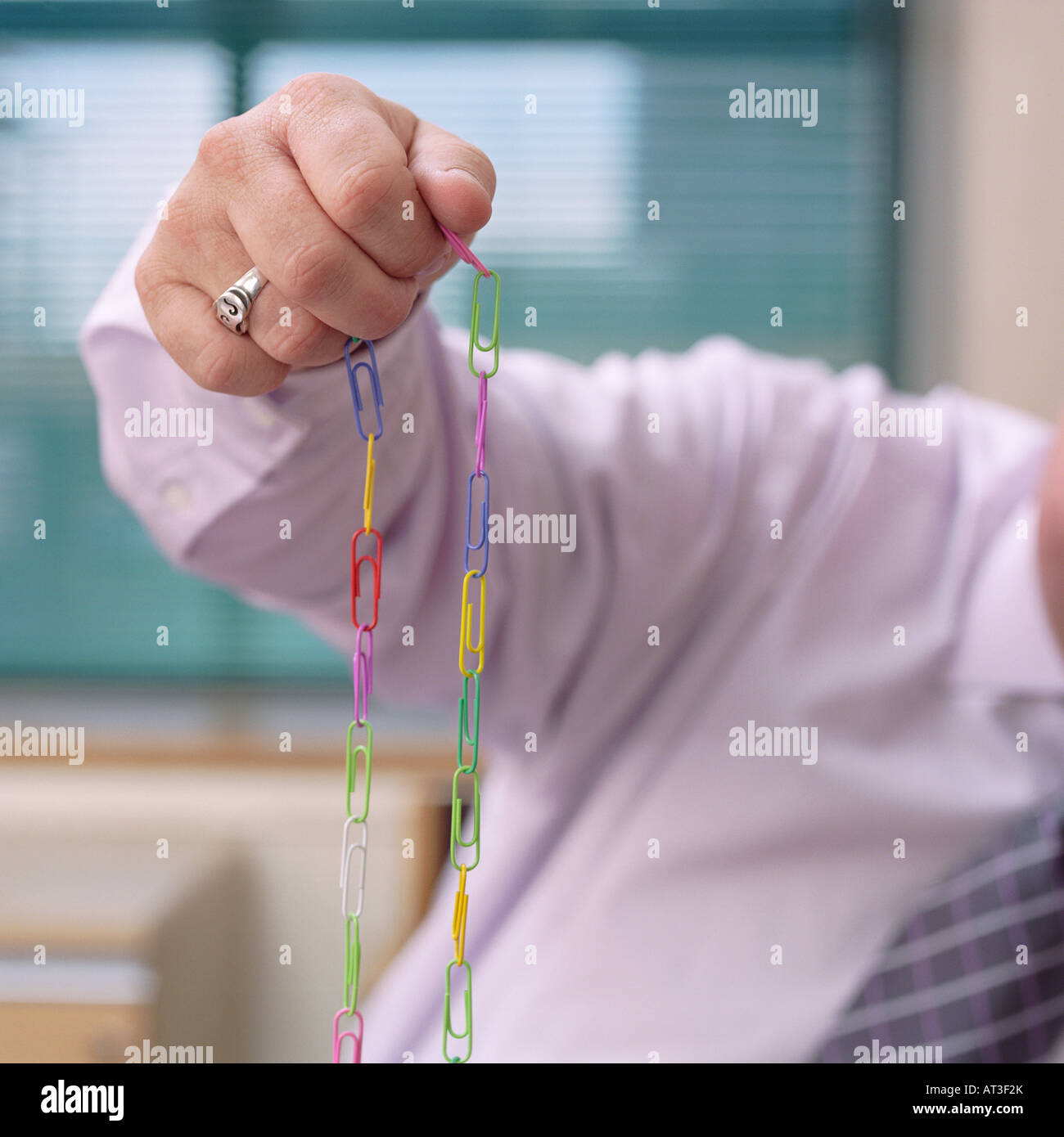 A businessman holding a string of paperclips Stock Photo - Alamy