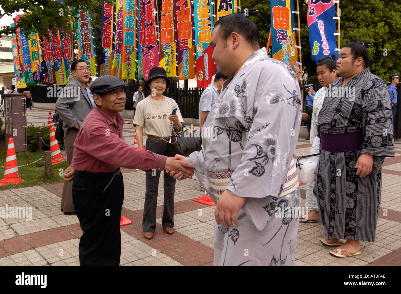 Sumo wrestlers meet their fans outside the Ryogoku stadium after a ...