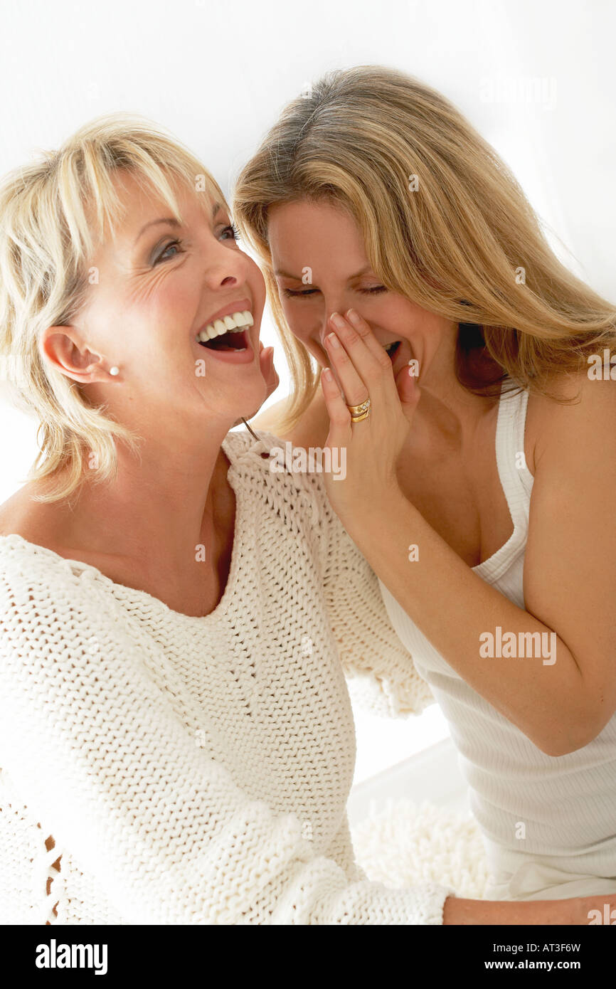 Two women gossiping together Stock Photo - Alamy