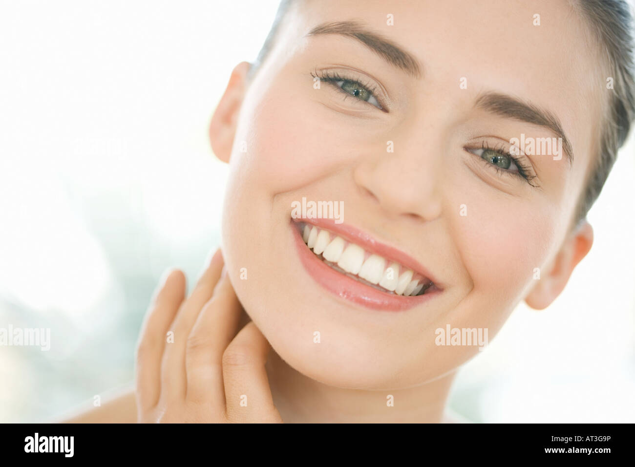 Portrait of young woman smiling, head on one side Stock Photo - Alamy