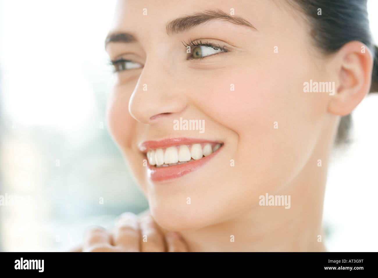 Portrait of young woman smiling, head turned to one side Stock Photo ...