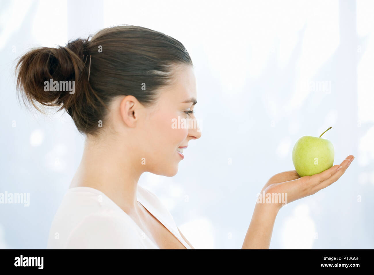 Young woman holding apple, side view Stock Photo - Alamy