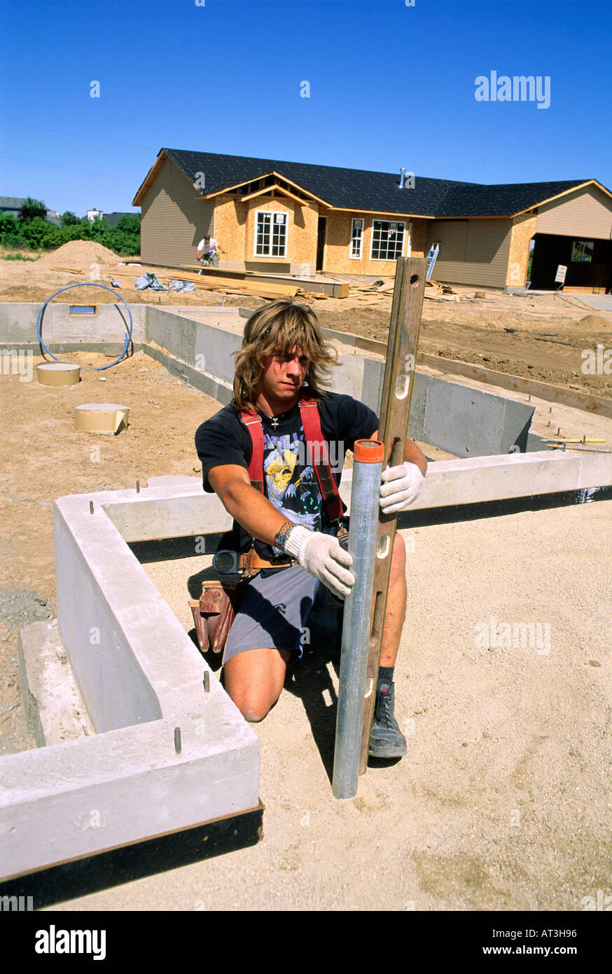 Housing construction worker uses a level to install a pipe in Boise ...