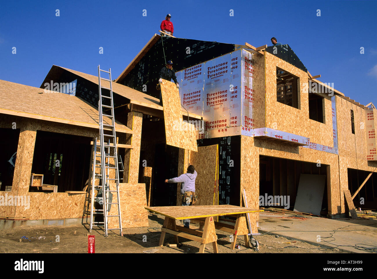 Construction workers building a new home in Idaho using particle board ...