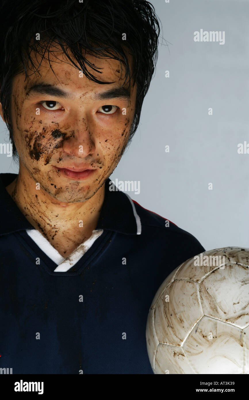 Soccer player with face covered in mud Stock Photo - Alamy