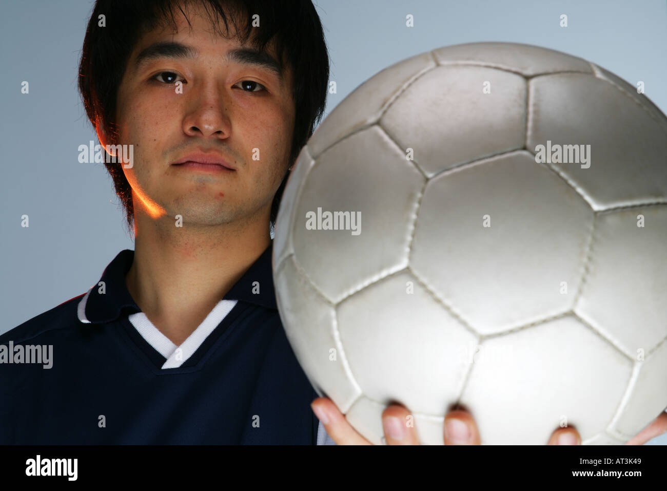 Determined soccer player holding ball Stock Photo - Alamy