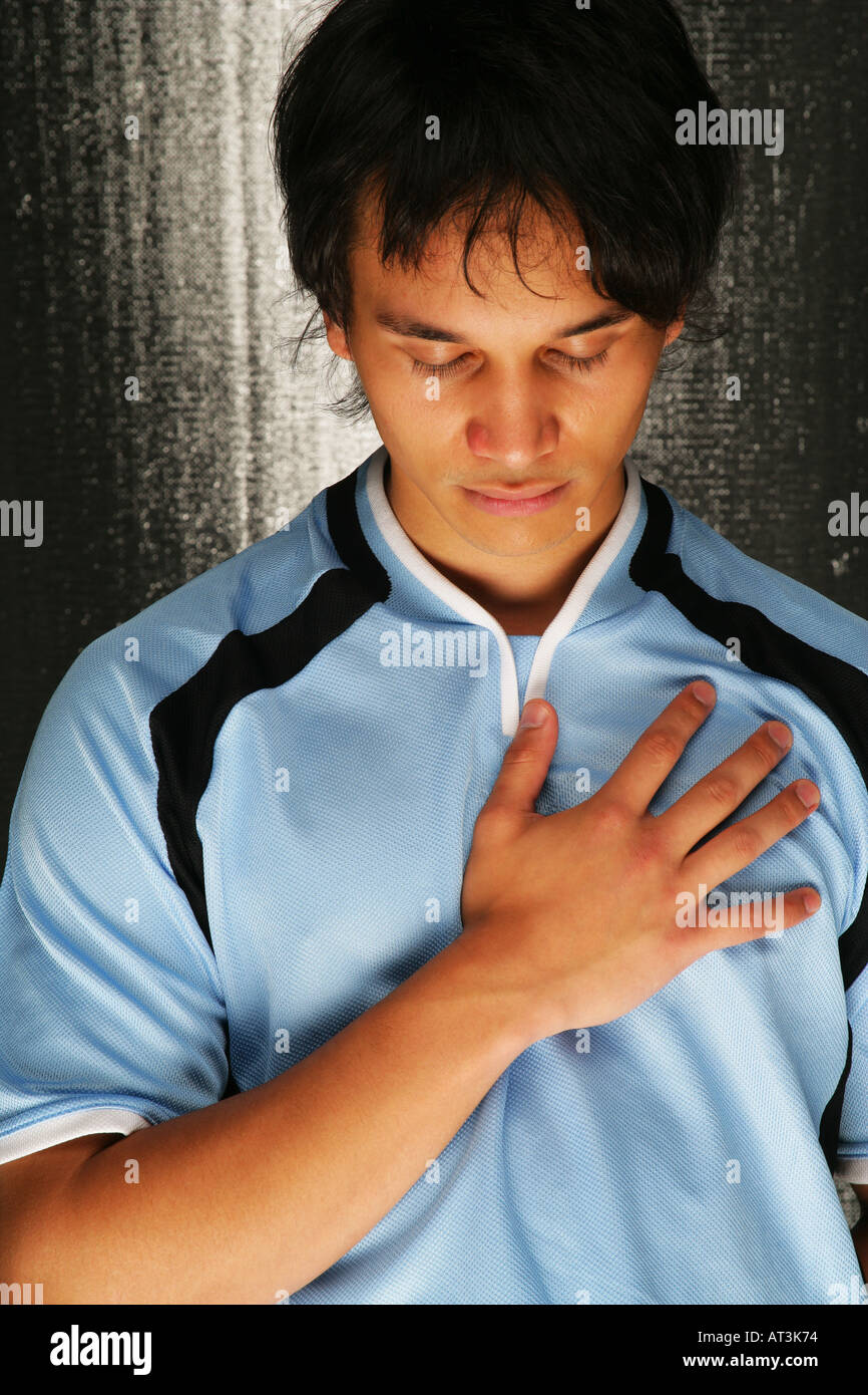 Soccer player with hand on heart Stock Photo - Alamy