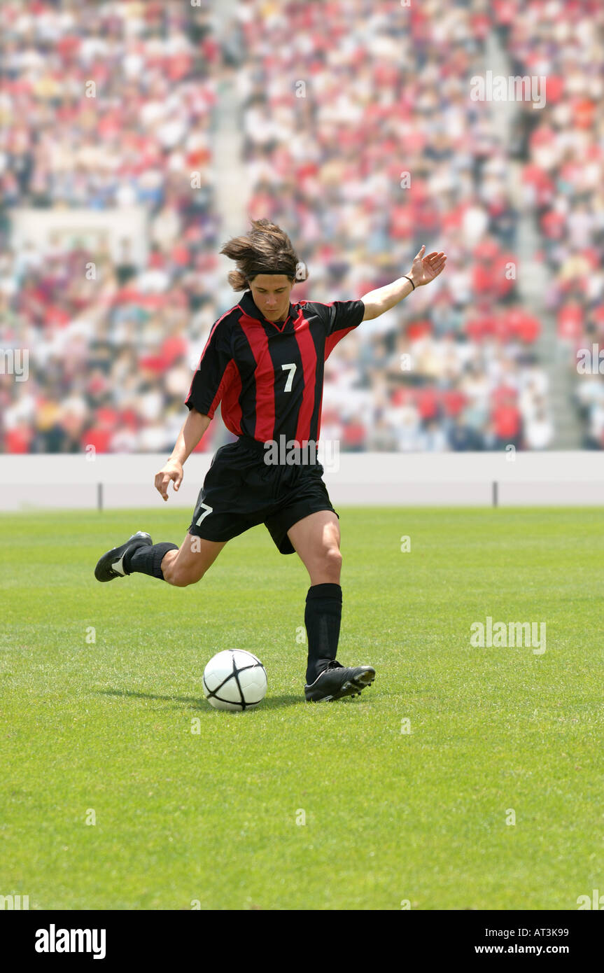Soccer player striking ball Stock Photo - Alamy