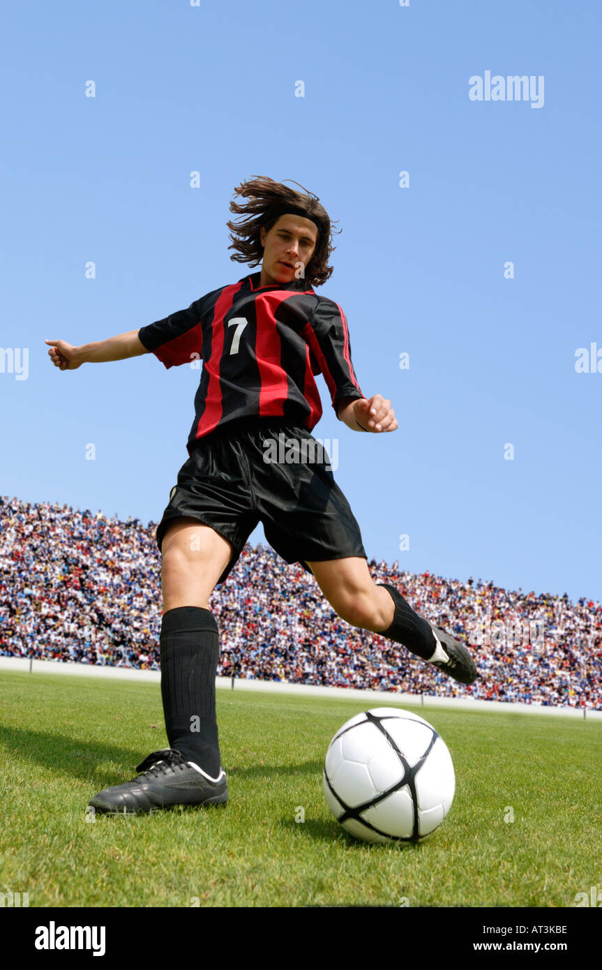 Soccer player striking ball Stock Photo - Alamy