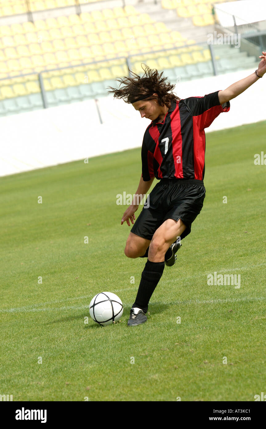 Soccer player striking ball Stock Photo - Alamy