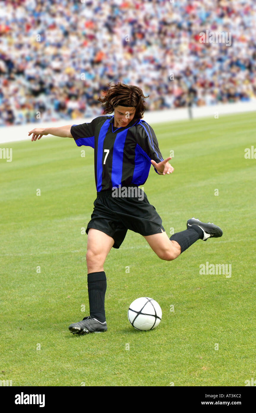 Soccer player striking ball Stock Photo - Alamy