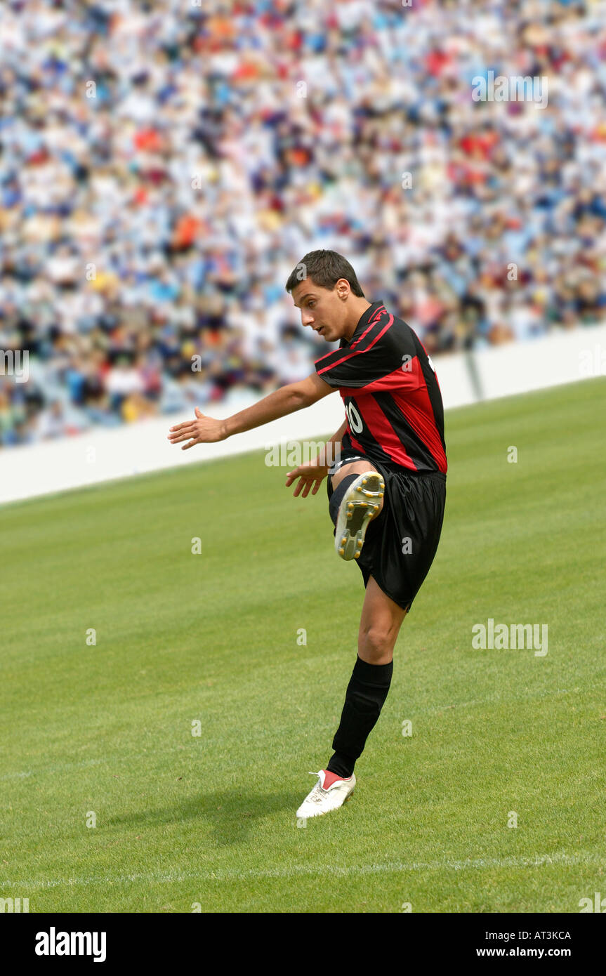 Soccer player striking ball Stock Photo - Alamy