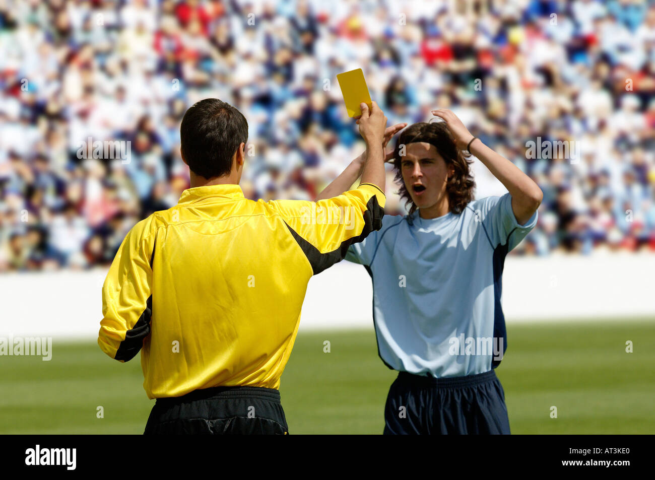 Referee showing yellow card to disappointed player Stock Photo - Alamy