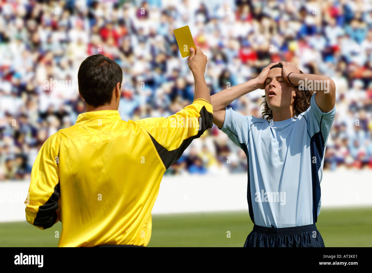 Referee showing yellow card to disappointed player Stock Photo - Alamy