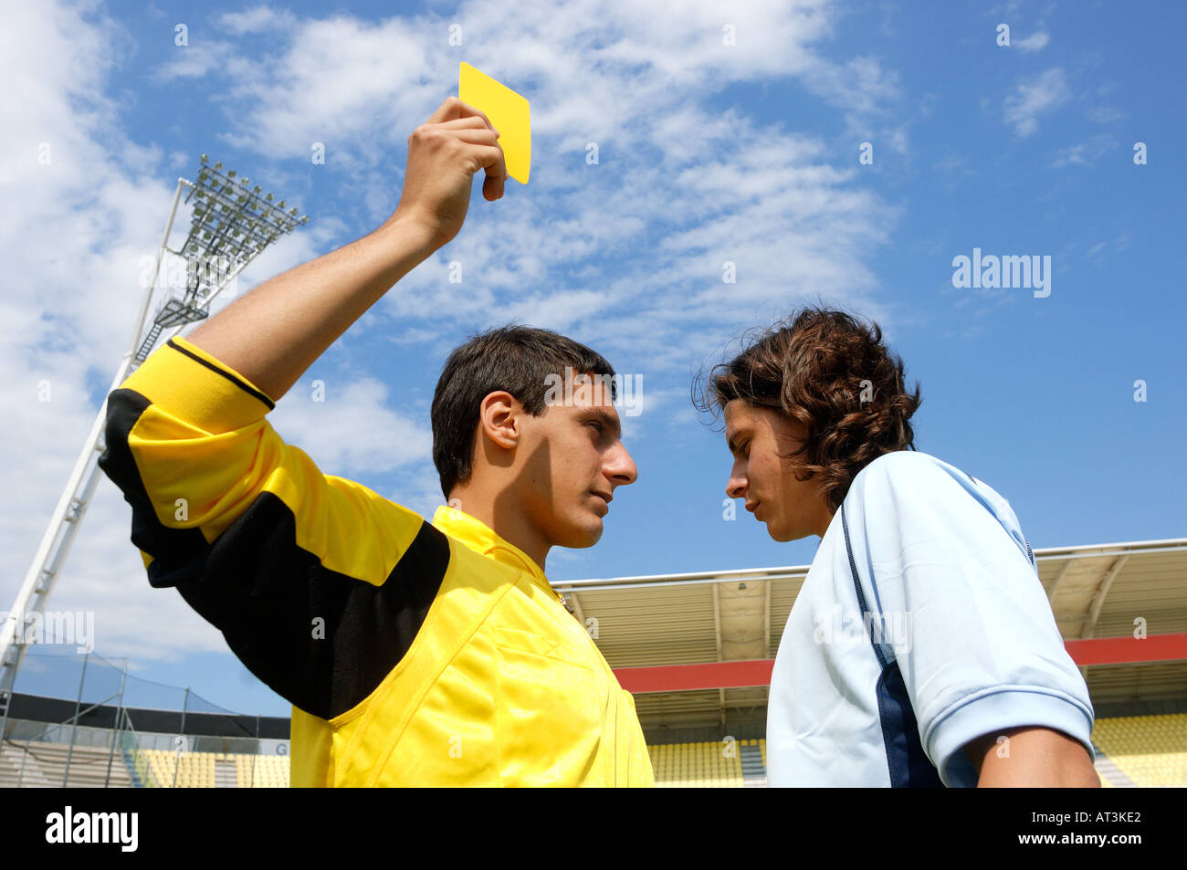 Referee showing yellow card to disappointed player Stock Photo - Alamy