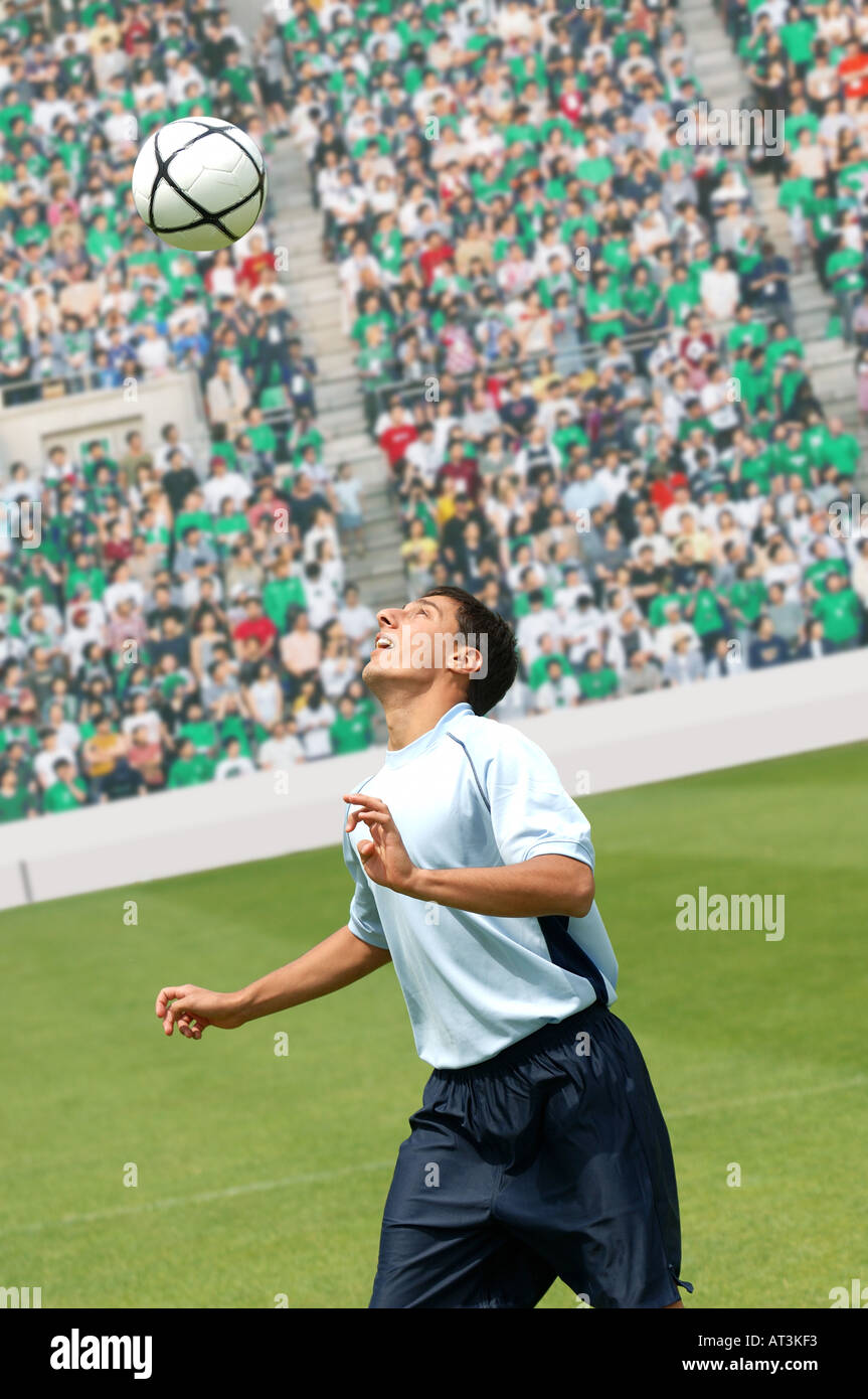 Soccer player juggling ball on head Stock Photo - Alamy