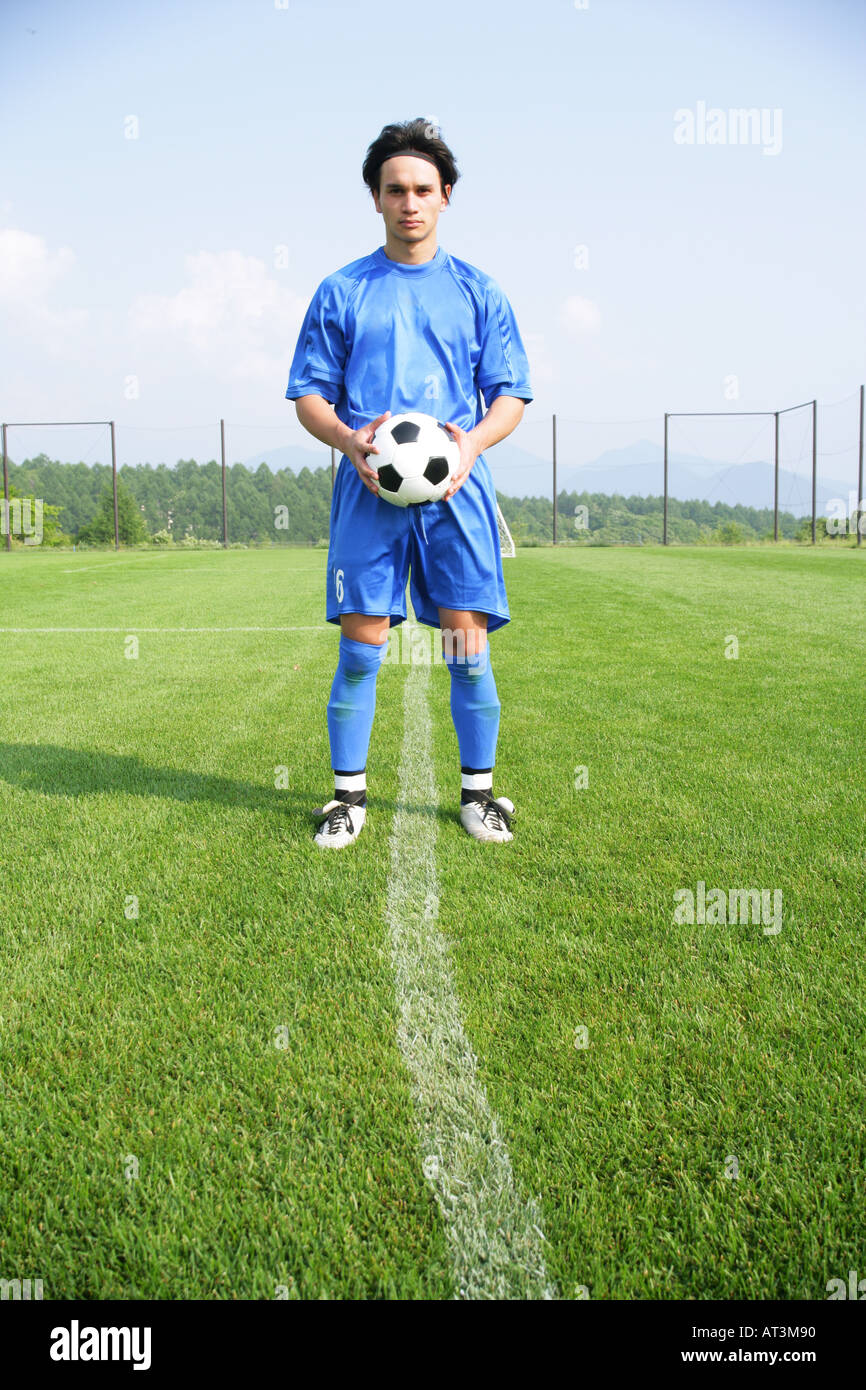 Soccer player holding ball on touchline Stock Photo - Alamy