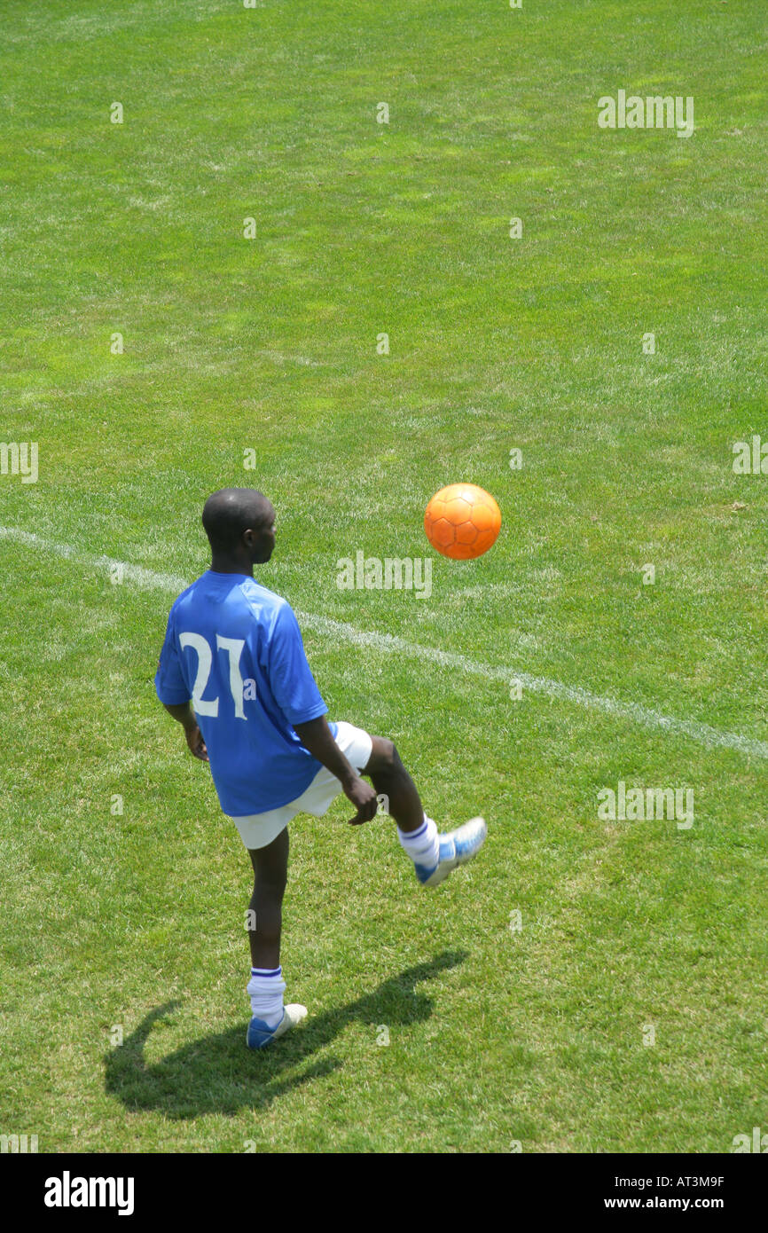 Soccer player juggling ball on sideline Stock Photo - Alamy