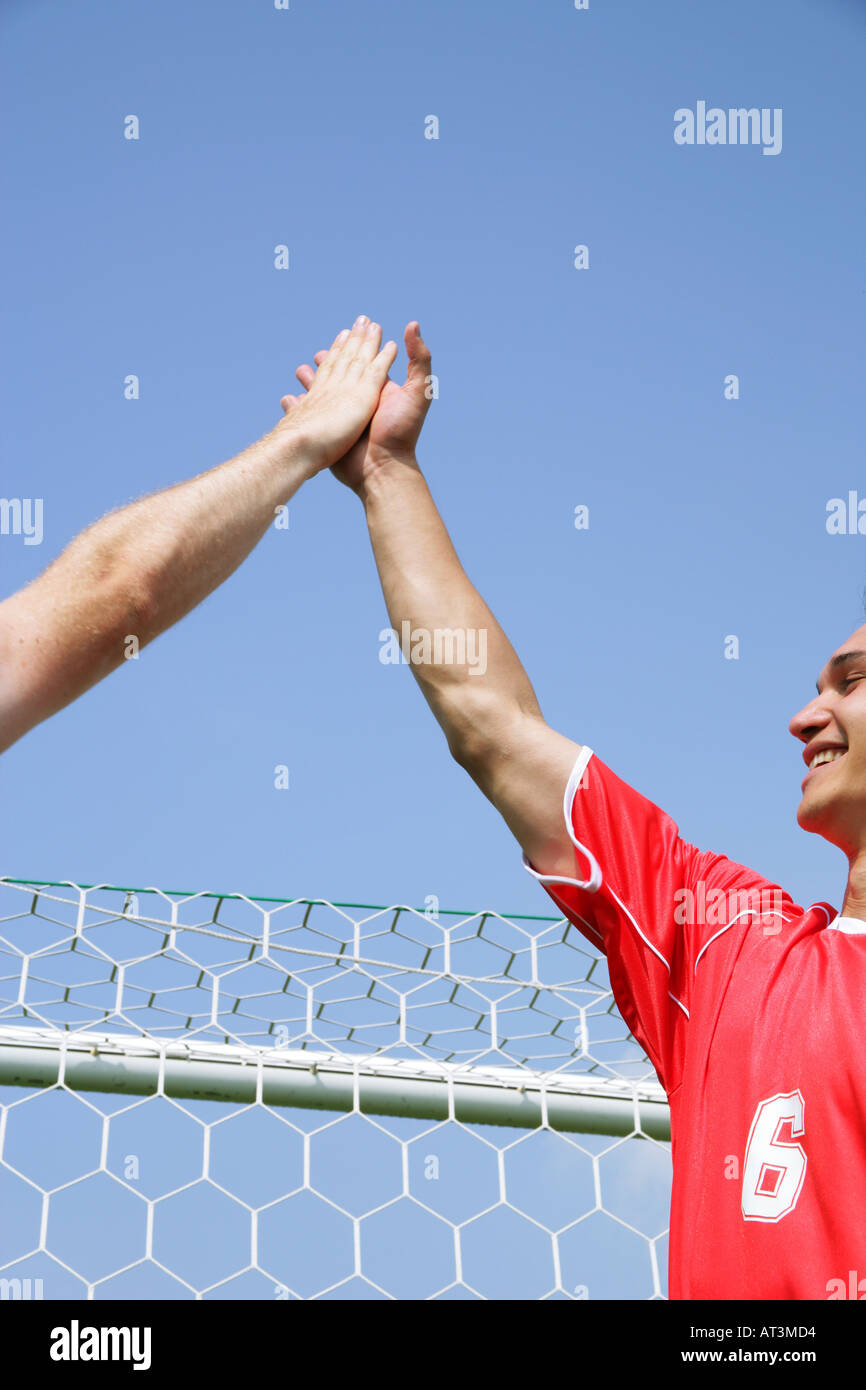 Team mates give each other a high five Stock Photo - Alamy