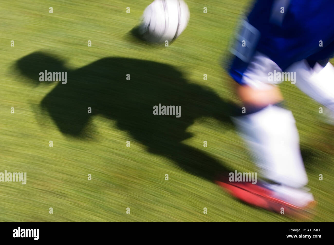 Shadow of soccer player running with ball Stock Photo - Alamy