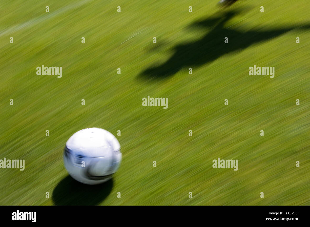 Shadow of soccer player running with ball Stock Photo - Alamy