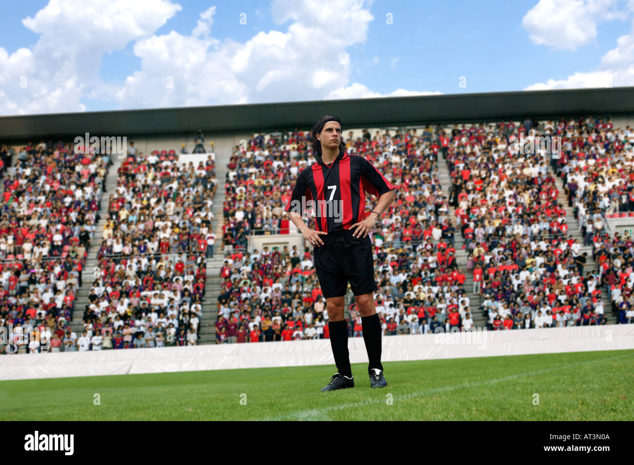 Soccer player standing on pitch Stock Photo - Alamy