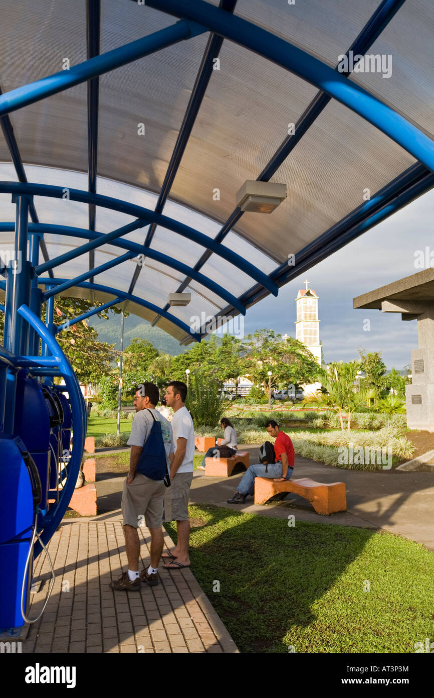 Costa Rica La Fortuna Parque Central tourists at covered phone booths ...