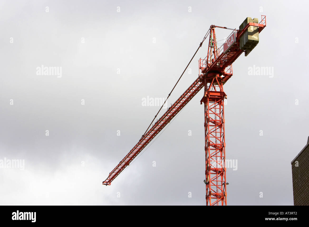 red crane against grey cloudy sky working on construction site in and ...