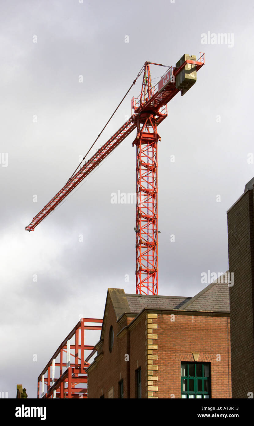 red crane against grey cloudy sky working on construction site in and ...