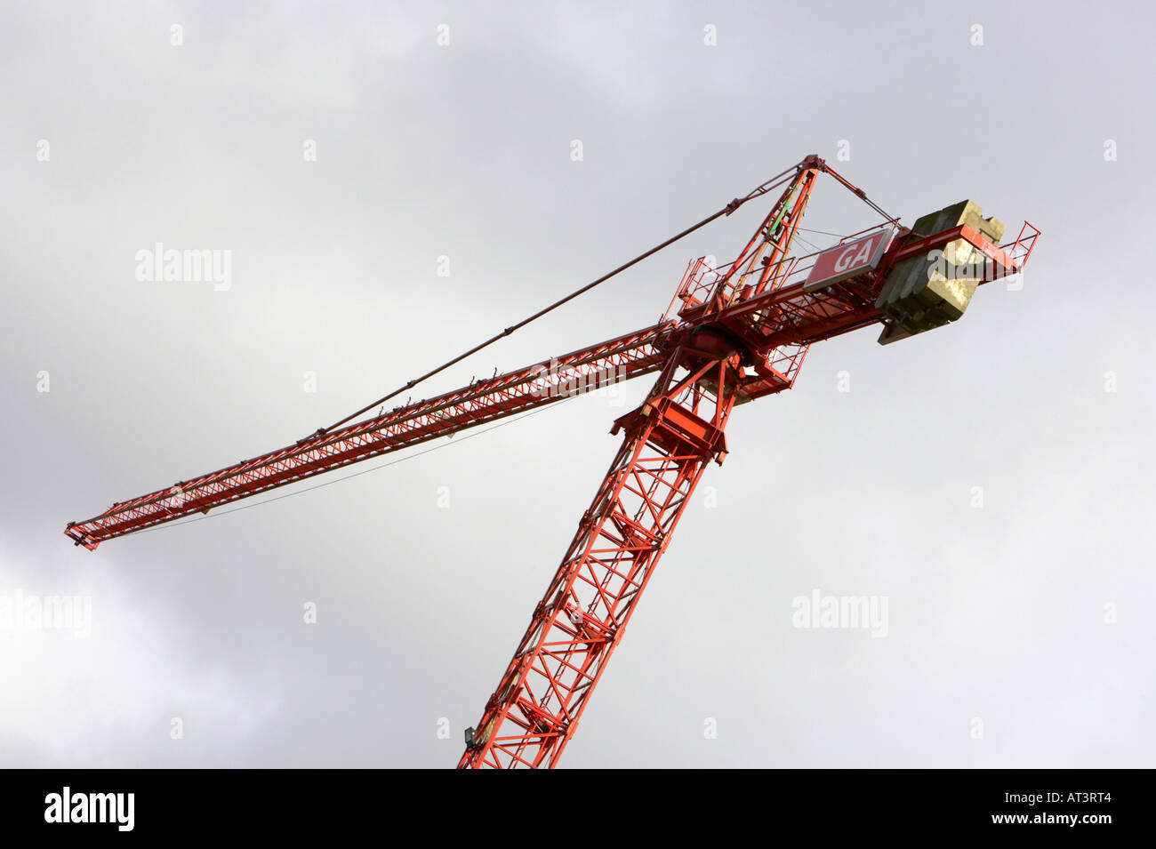 red crane against grey cloudy sky working on construction site in and ...