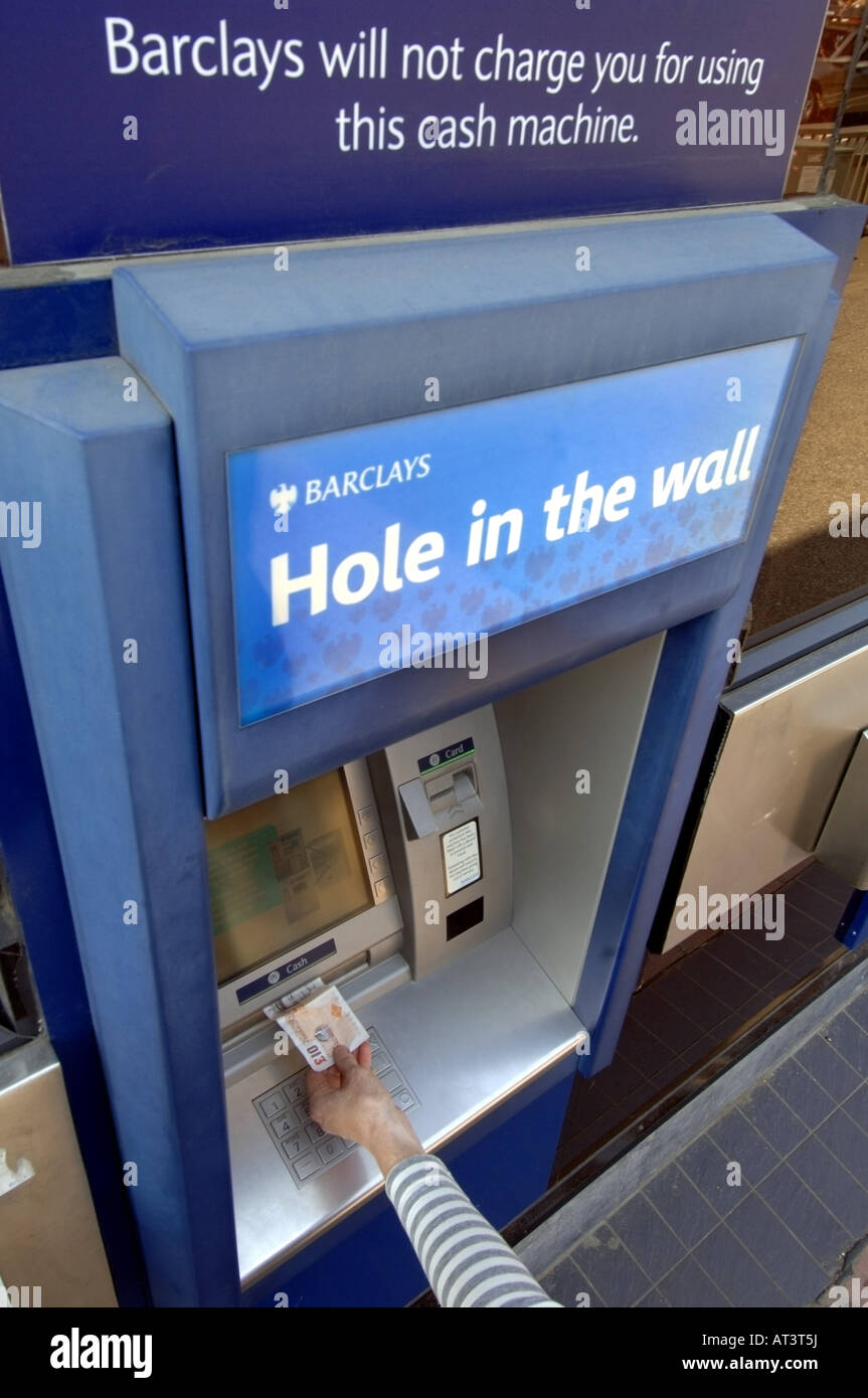 A Barclays Bank Hole In The Wall Cashpoint with someone holding cash ...
