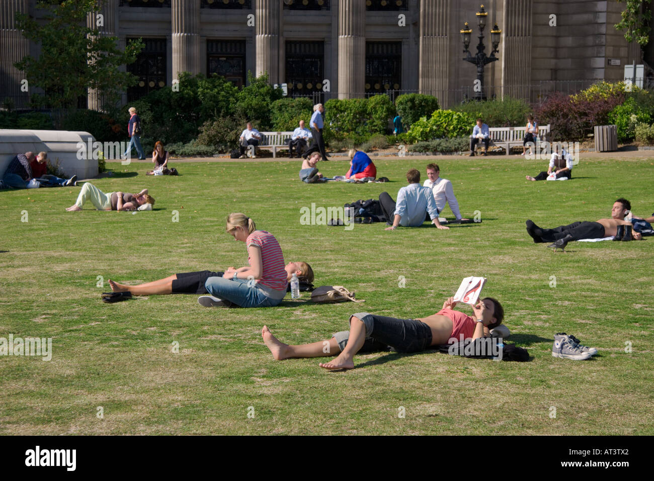 Office workers relaxing at lunchtime in small square by Trinity House ...