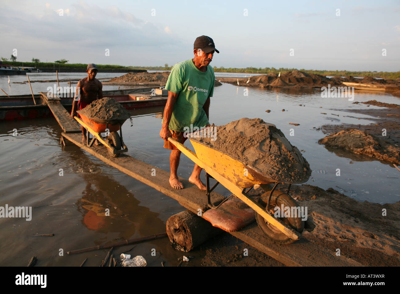 Poor people dig sand from the bottom of the river and transport it with ...