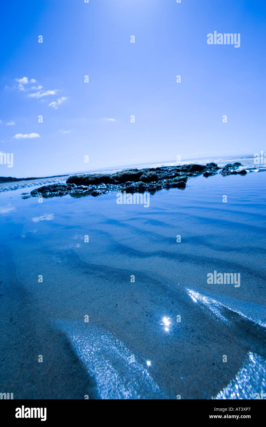 Blue sky sea and ripples of water on a sandy beach Stock Photo - Alamy